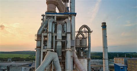 높은 콘크리트 공장 구조와 산업 생산 현장의 타워 크레인이 있는 시멘트 공장의 조감도 제조 및 글로벌 산업 개념 사진