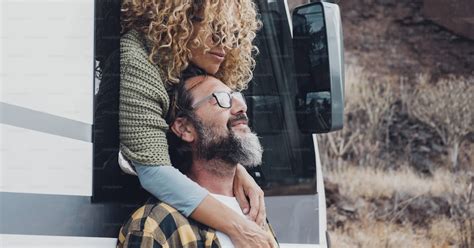 목적지에서 사랑에 빠진 행복한 커플과 함께 차량 컨셉의 라이프스타일로 여행하세요 여자는 수염을 가진 남자를 껴안는다 배경의