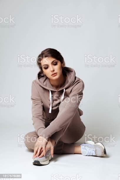 흰색 스튜디오 배경에 스포티 한 정장과 운동화를 입은 젊은 매력적인 여성 20 24세에 대한 스톡 사진 및 기타 이미지 20 24세 갈색 머리 건강한 생활방식