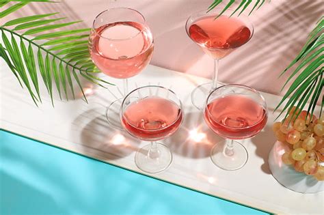 화이트 와인 알코올 마가리타 칵테일 및 긴 단단한 그림자가있는 파스텔 배경에 포도가있는 현대 정물화 0명에 대한 스톡 사진 및