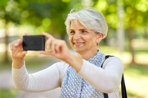 Premium Photo Senior Woman Photographing By Cell At Summer Park