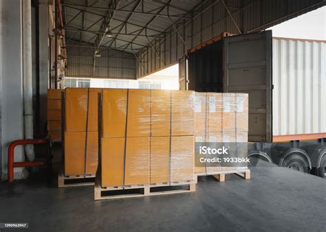 포장 상자는 선적화물 컨테이너로 적재하는 팔레트에 플라스틱을 포장했습니다 트럭은 도크 창고에 적재를 주차했다 선적 공급망 유통화물 트럭 운송 물류 하역장에 대한 스톡 사진