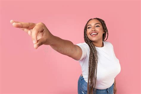 black plus size female giving invisible object over pink background