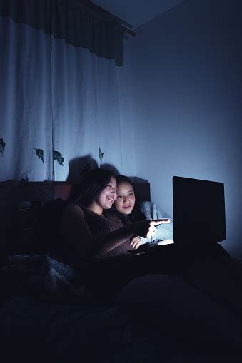 두 명의 히스패닉 젊은 여성이 침대에 누워 노트북으로 어둠 속에서 영화를 보는 세로 샷 2명에 대한 스톡 사진 및 기타 이미지 2명 갈색 머리 감정 Istock