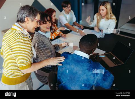 A Teacher Guides A Diverse Group Of Pupils During A Collaborative Classroom Session Fostering