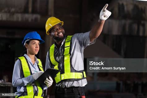 남성과 여성 엔지니어 그룹은 산업 공장 지역에서 중금속 기계를 점검하거나 유지하기 위해 디지털 태블릿으로 작업합니다 기술자 팀은