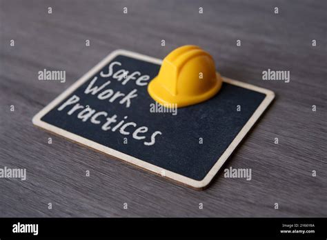 Small Chalkboard With The Text “safe Work Practices” And Yellow Hard Hat Concepts Of Safety
