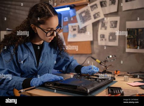 Female Engineer Fixing Broken Computer Motherboard In Workshop Laptop Disassembling With
