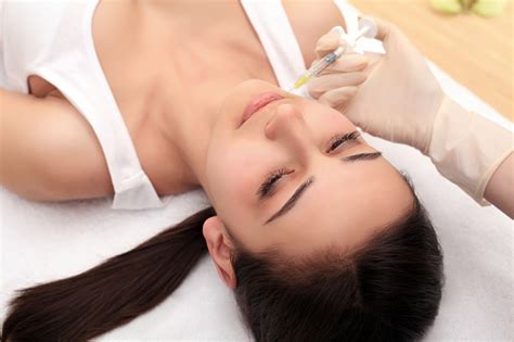 얼굴 입술에에서 주입 하는 미용사의 손 젊은 여자 얼굴 주사를 살롱에서 아름다움을 가져옵니다 얼굴 노화 회복 및 수 분