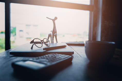 아침에 노트북 컴퓨터와 커피 컵에 안경이있는 홈 오피스의 책상 프리랜서는 미래에 젊은 비즈니스 개념의 가정에서 일 0명에 대한