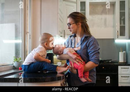 Jeune mère détient sa petite fille suce et baise avec son fils Garçon est assis pieds nus sur