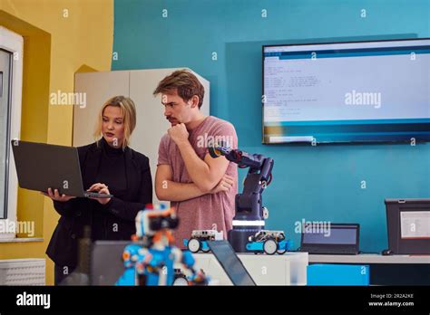 A Group Of Colleagues Working Together In A Robotics Laboratory