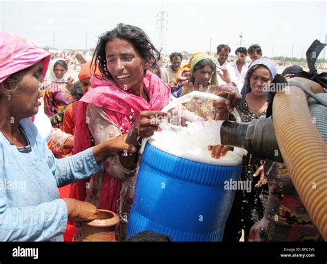Flood Affected Women Fill Their Water Pots At A Drinking Water Tank At Flood Affectees Relief