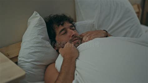 Young Hispanic Man Lying On Bed Sleeping Shirtless At Bedroom Stock