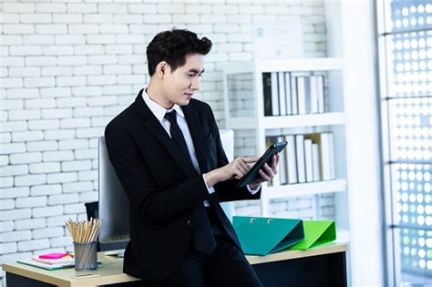 행복한 분위기 쾌활한 성공적인 아시아 젊은 사업가 사무실에서 나무 테이블 배경에 스마트 폰과 노트북 컴퓨터와 함께 일 휴대용 통신 기기에 대한 스톡 사진 및 기타 이미지