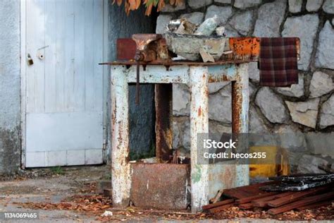 석조 벽과 잠긴 문 배경에 건축 자재와 쓰레기로 둘러싸인 오래 된 금속 테이블에 장착 된 녹슨 워크 벤치 바이스 0명에 대한 스톡 사진 및 기타 이미지 Istock