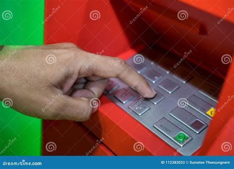 a man hand entering pin pass code on atm bank machine keypad stock