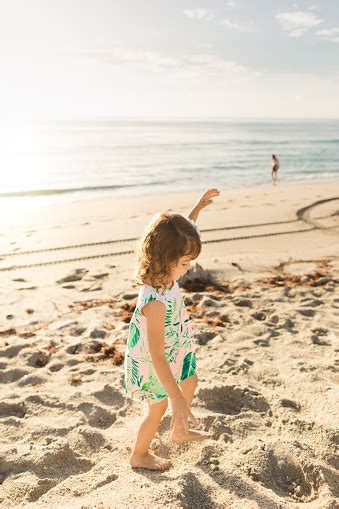 2022년 9월 플로리다 팜비치의 모래 해변에서 조개껍데기를 모으는 화려한 교대 드레스를 입은 3세 유아 소녀 가정 생활에 대한 스톡 사진 및 기타 이미지 Istock