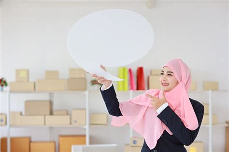 무슬림 파란색 정장을 입은 활동적인 아시아 여성이 온라인 패키지 상자 배달 배경으로 하얀 말풍선을 들고 있다 스타트업 중소기업 프리랜서 소녀는 행복한 얼굴로 집에서 일한다