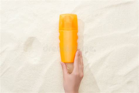 Cropped View Of Woman Holding Orange Sunscreen Lotion Above Golden Sand