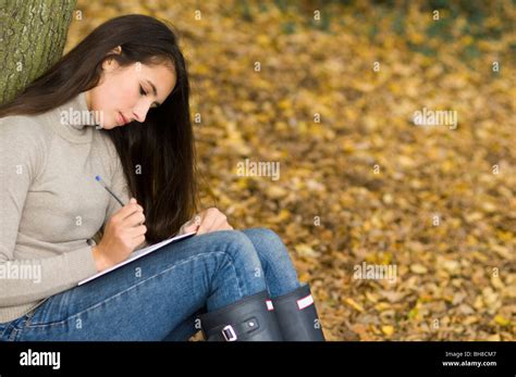 Girl Writing Against A Tree Stock Photo Alamy