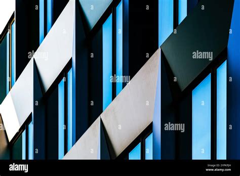 Abstract Close Up Of Modern Building Facade With Angular Patterns And Reflective Blue Windows