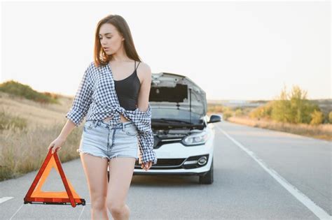 Premium Photo Beautiful Sexy Woman Holding An Emergency Stop Sign Near A Broken Car