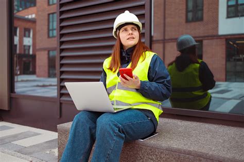 건설 현장에 서있는 열심히 일하는 여성 건설 엔지니어 자신감있는 엔지니어가 전화로 이야기하고 케이싱 작업이 진행 중임을 보여줍니다 건설 산업에 대한 스톡 사진 및 기타
