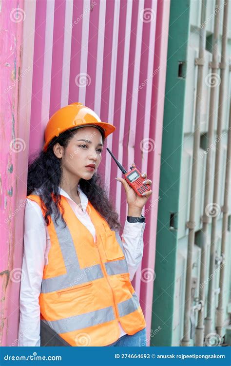 Portrait Of Female Worker In Cargo Containers In Shipping Container Yard Woman Holding Walkie