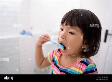 Portrait d une petite fille très intelligente se brosser les dents est