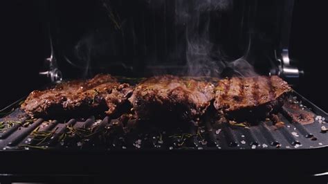 그릴에 맛있는 육즙 고기 스테이크 요리 전기 로스터 로즈마리 후추 소금에 쇠고기 튀김 슬로우 모션 영화 음악에 대한 스톡 사진