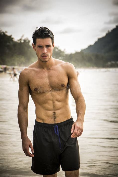 Красивый молодой элегантный человек в костюме ослабляя сидит на стуле руки Стоковое Фото