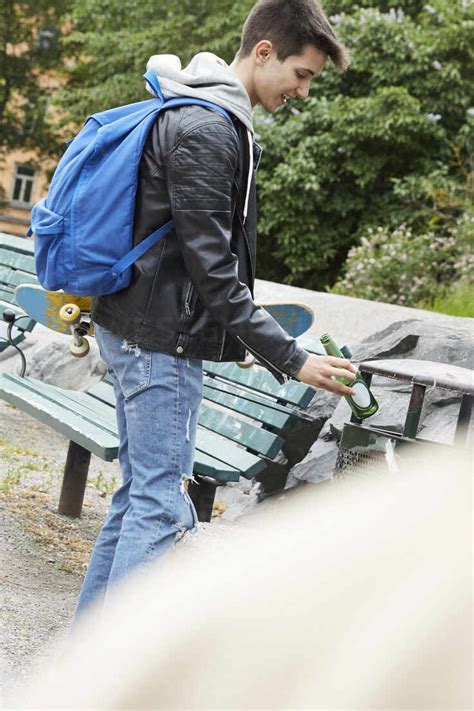 Smiling Man Throwing Bottle In Garbage Can Stock Photo