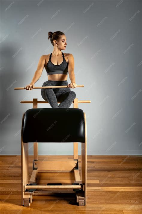Premium Photo Pilates Trainer Exercises On A Pilates Barrel Body