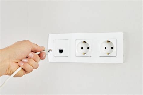 Premium Photo Close Up Of A Man Hand Plugging An Ethernet Cable Into A Wall Socket