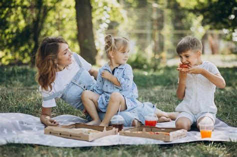 Mãe Com Filho E Filha Comendo Pizza No Parque Foto Grátis