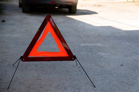 고장난 차가 수리를 기다리고 있는 도로에 빨간 비상 정지 표지판이 있습니다 도로 안전을 위해 차량 사고나 고장에 대비하여 도로에 설치된 적색 비상 정지 표지판을