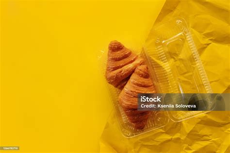 노란색 배경에 플라스틱 포장에 갓 구운 크루아상 테이크 아웃 음식 개념 프랑스와 미국 크루아상은 전 세계적으로 즐길 수 있습니다 크루아상 배경 상단 보기 플랫 레이 0명에