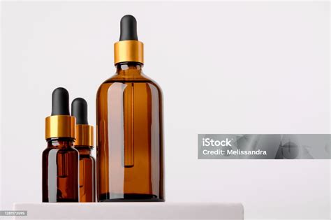 스탠드에 흰색 배경에 에센셜 오일이있는 갈색 유리 병 세트 대체 의학 치료를위한 파이펫과 미용 제품의 포장 아로마테라피 동종