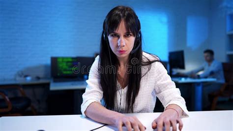 Serious Slim Beautiful Woman Putting On Headphones And Typing On
