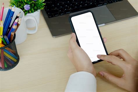 현대 사무실에서 나무 책상에 빈 화면 스마트폰을 들고 있는 사업가 사진 Unsplash의 태국 이미지