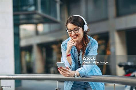 젊은 여자는 도시에 스마트폰 및 헤드폰을 통해 영상 통화를 만들기 도시에 대한 스톡 사진 및 기타 이미지 도시 명랑한 모던 양식 Istock
