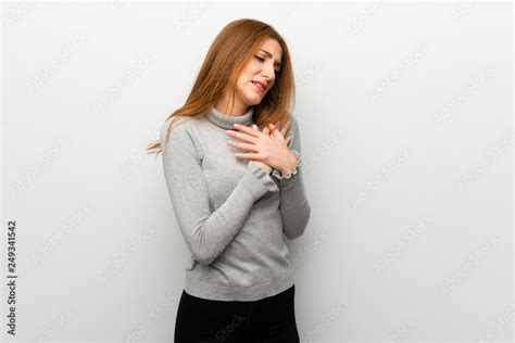 Redhead Girl Over White Wall Having A Pain In The Heart Stock Photo Adobe Stock