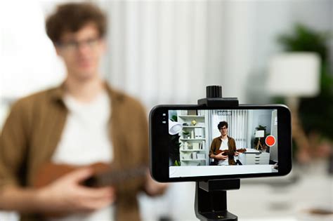 인플 루 언서 노래 기타 연주 흐림 배경에 초점 전화보기 거셔 Brand Name Smart Phone에 대한 스톡 사진 및 기타 이미지 Brand Name Smart