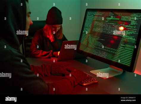 anonymous people using computer and programming to break code cyber