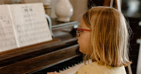의자에 앉아 피아노를 연주하는 어린 소녀 사진 Unsplash의 자녀 이미지