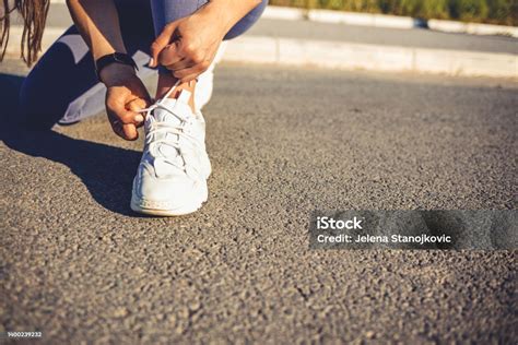 밖에서 운동하는 동안 신발 끈을 묶는 한 백인 여성의 클로즈업 편안한 착용감과 훈련 운동 중 트립을 방지하기 위해 운동화 신발을 고정하는 운동화 20 24세에 대한 스톡