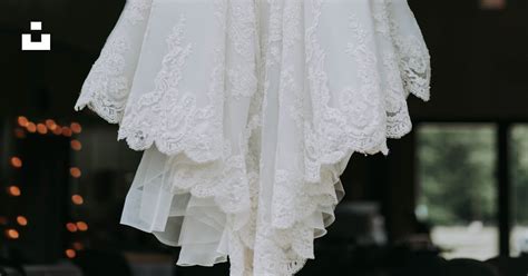 여자의 흰색 끈이없는 웨딩 드레스는 옷걸이에 매달려 있습니다 사진 Unsplash의 무료 결혼식 이미지