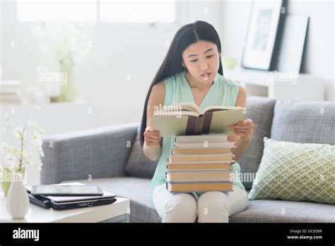 Woman With Stack Of Books At Home Stock Photo Alamy