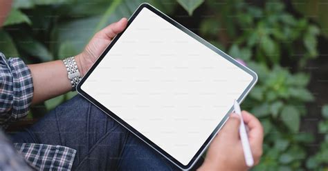 배경에 정원이 있는 빈 화면 태블릿으로 프로젝트를 진행하는 사업가의 자른 샷 사진 Unsplash의 컴퓨터 이미지